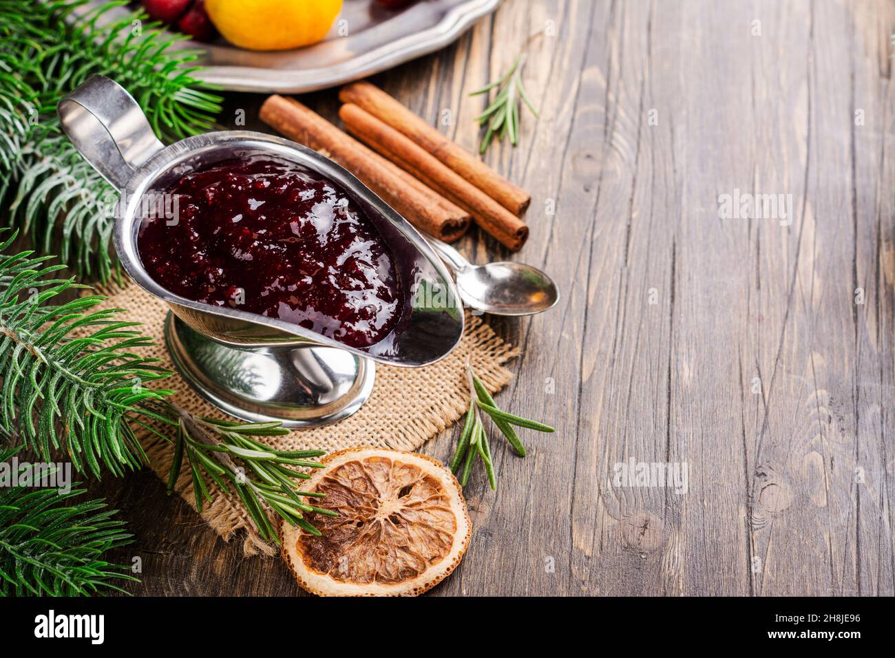 Cranberry sauce in ceramic saucepan with ingredients for cooking. Cranberry sauce for Christmas ...