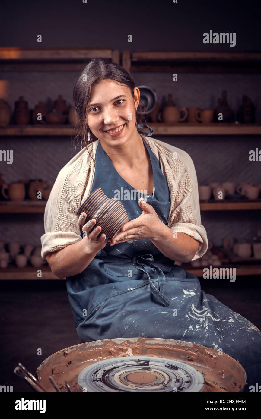 Pottery master demonstrates the finished clay product in a pottery ...