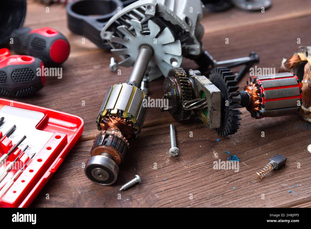 Details of electrical appliance and repair tools on a wooden table in a ...
