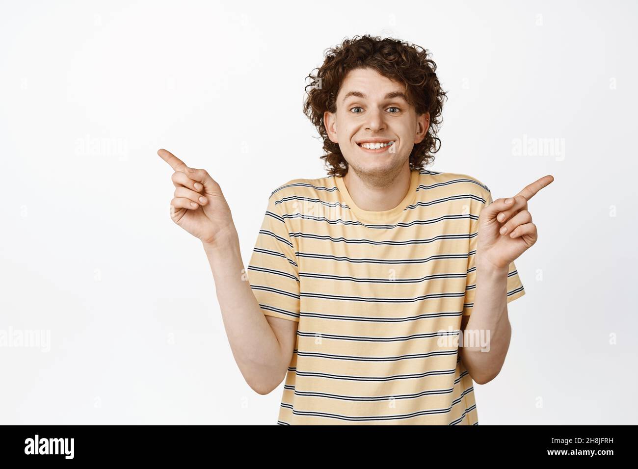 Excited smiling young man pointing left and right, showing two ways ...