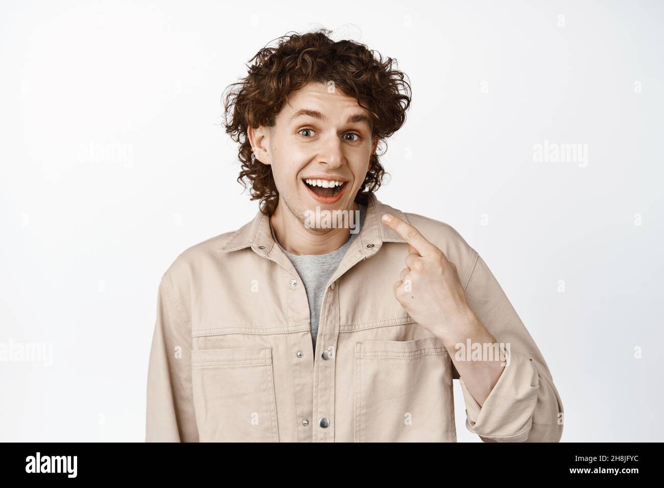 Excited young man pointing finger at himself and looking surprised ... Excited young man pointing finger at himself and looking surprised ...