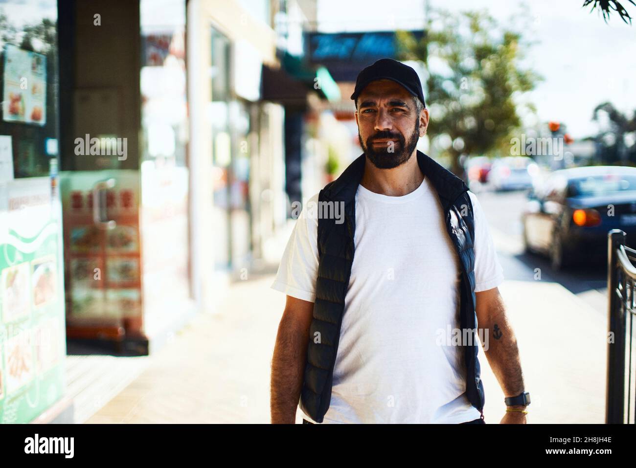 Man walking down the sidewalk in a town Stock Photo - Alamy