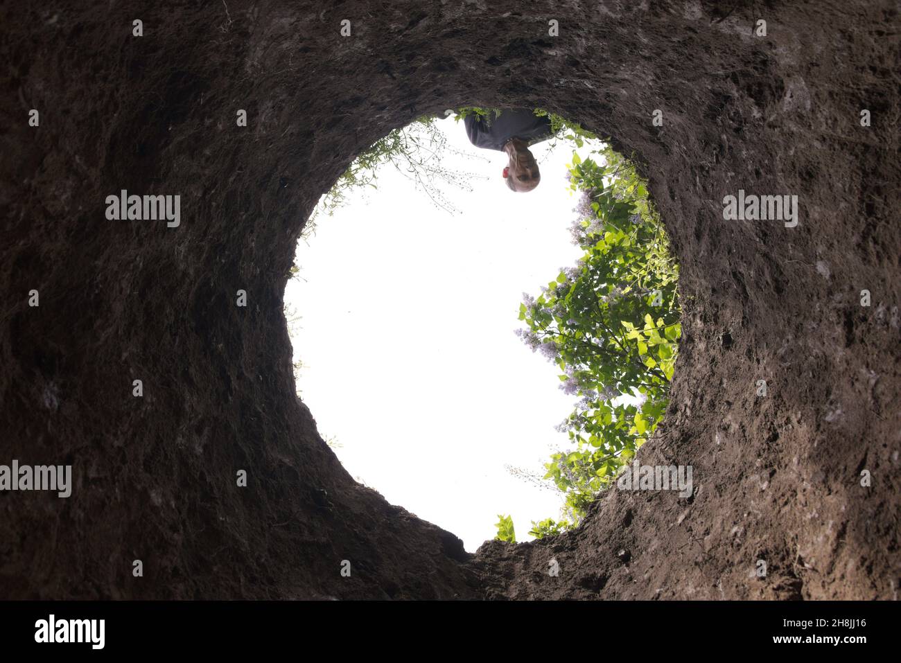 Man looks into a huge pit. View from the bottom of pit Stock Photo - Alamy