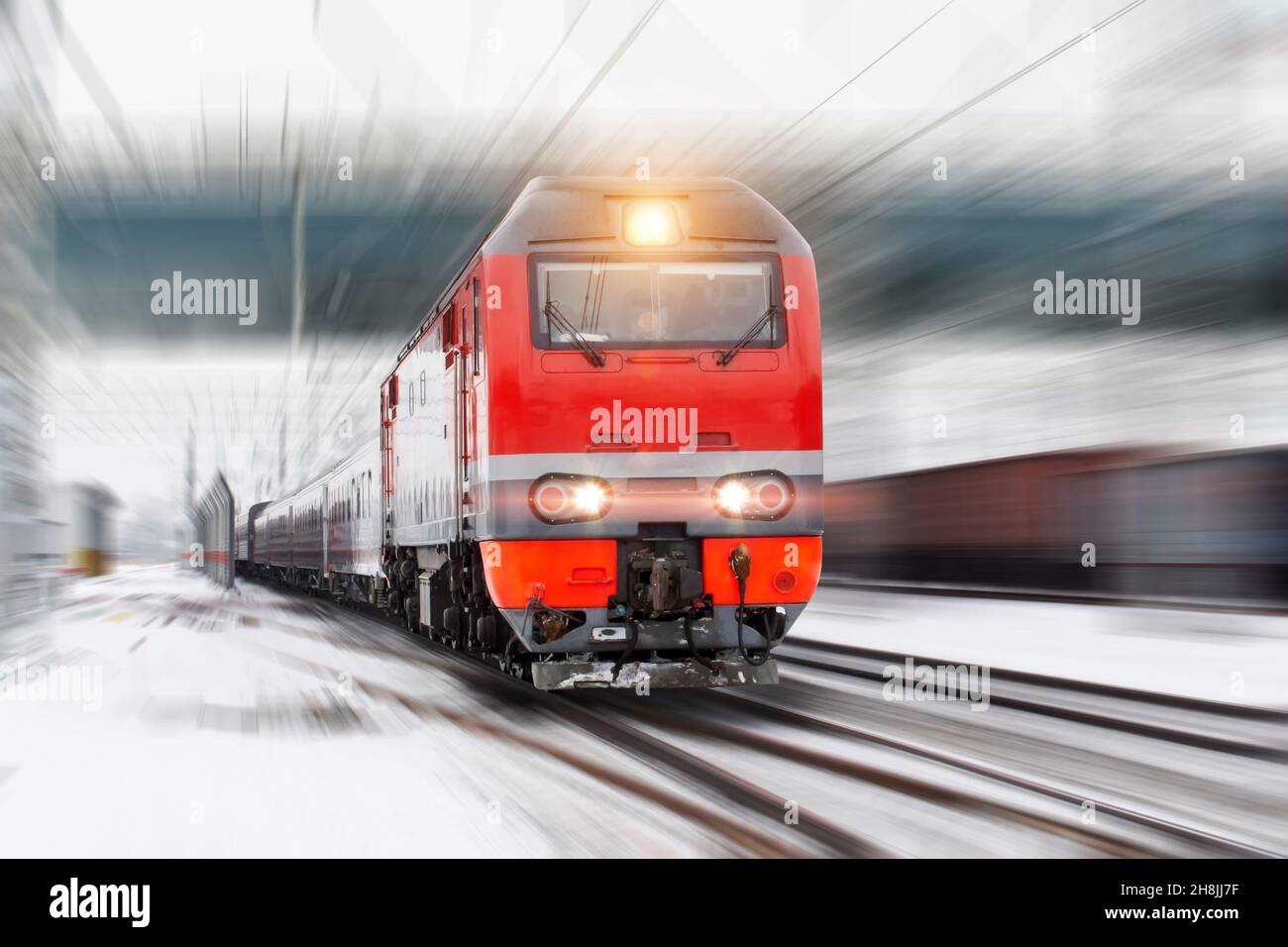Winter landscape on a high-speed railway road, a racing locomotive with ...