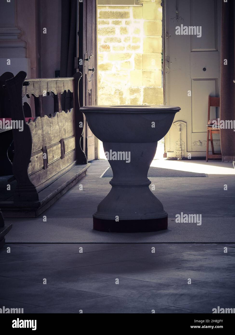 Vertical of a baptismal font in the church in front of the pews Stock ...