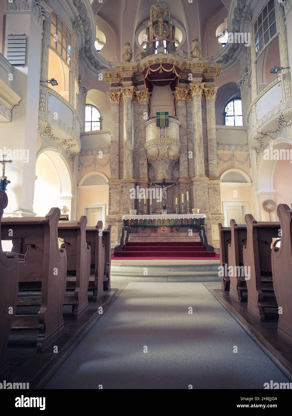 Vertical shot of a hall in the church with empty pews and an altar in ...