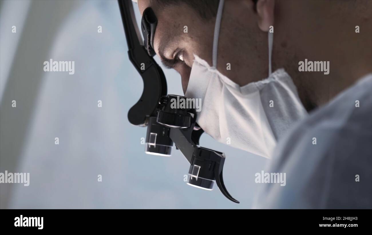 Surgeon head with professional glasses at work. Close up side view of a ...