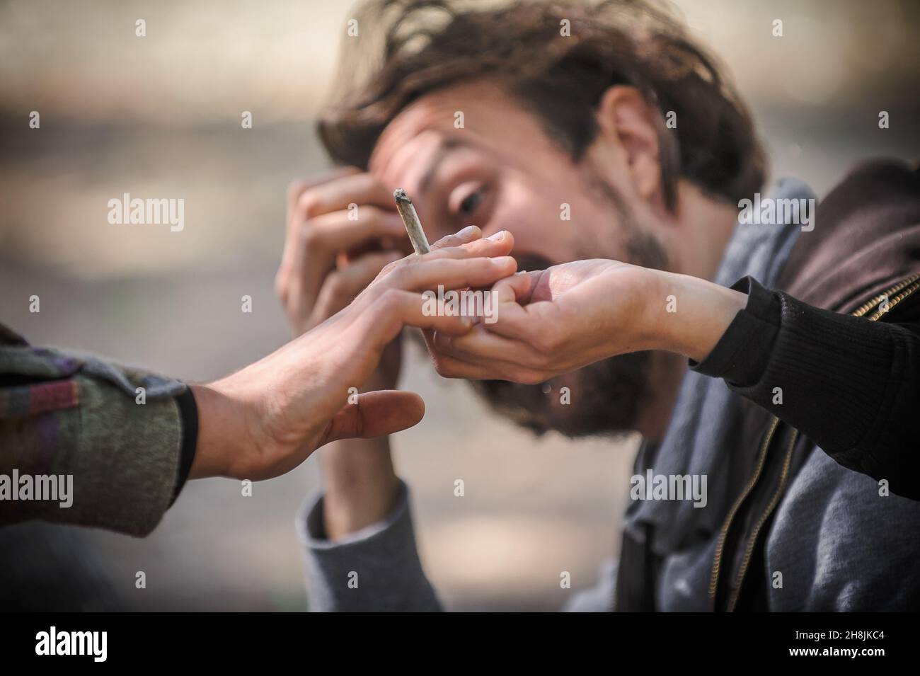 Closeup detail macro view of marijuana joint circling around from hand ...