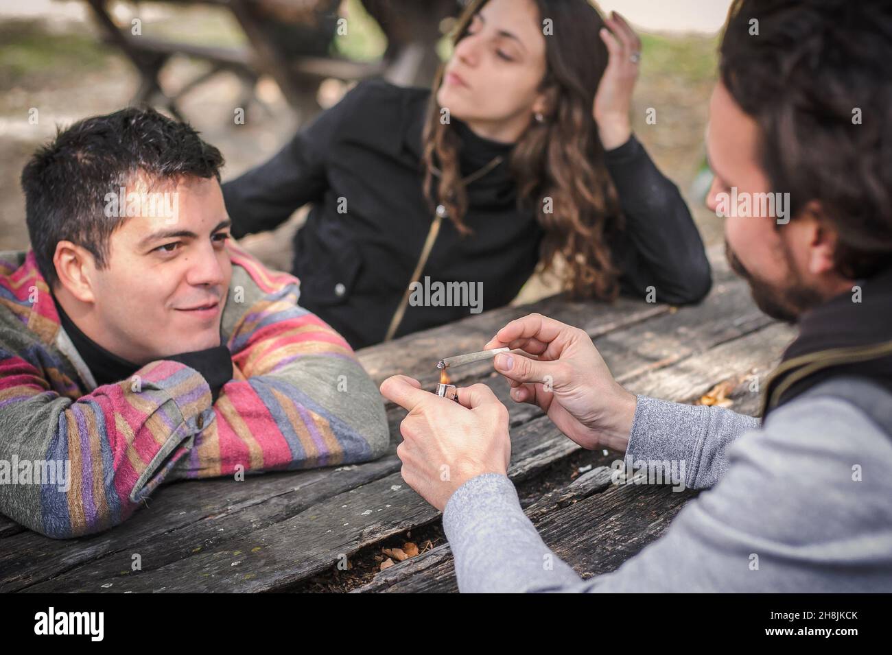 Man heats and lights marihuana or hashish joint cigarette to burn ...