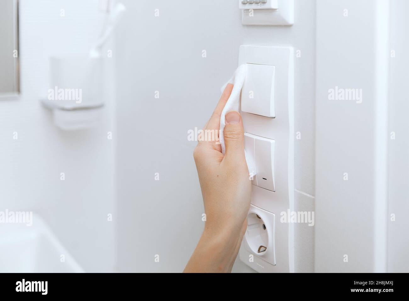 Cleaning switches and sockets with a microfiber cloth. Woman hand using ...