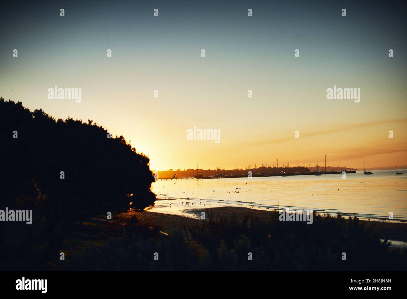 Sun setting/rising over ocean Stock Photo - Alamy