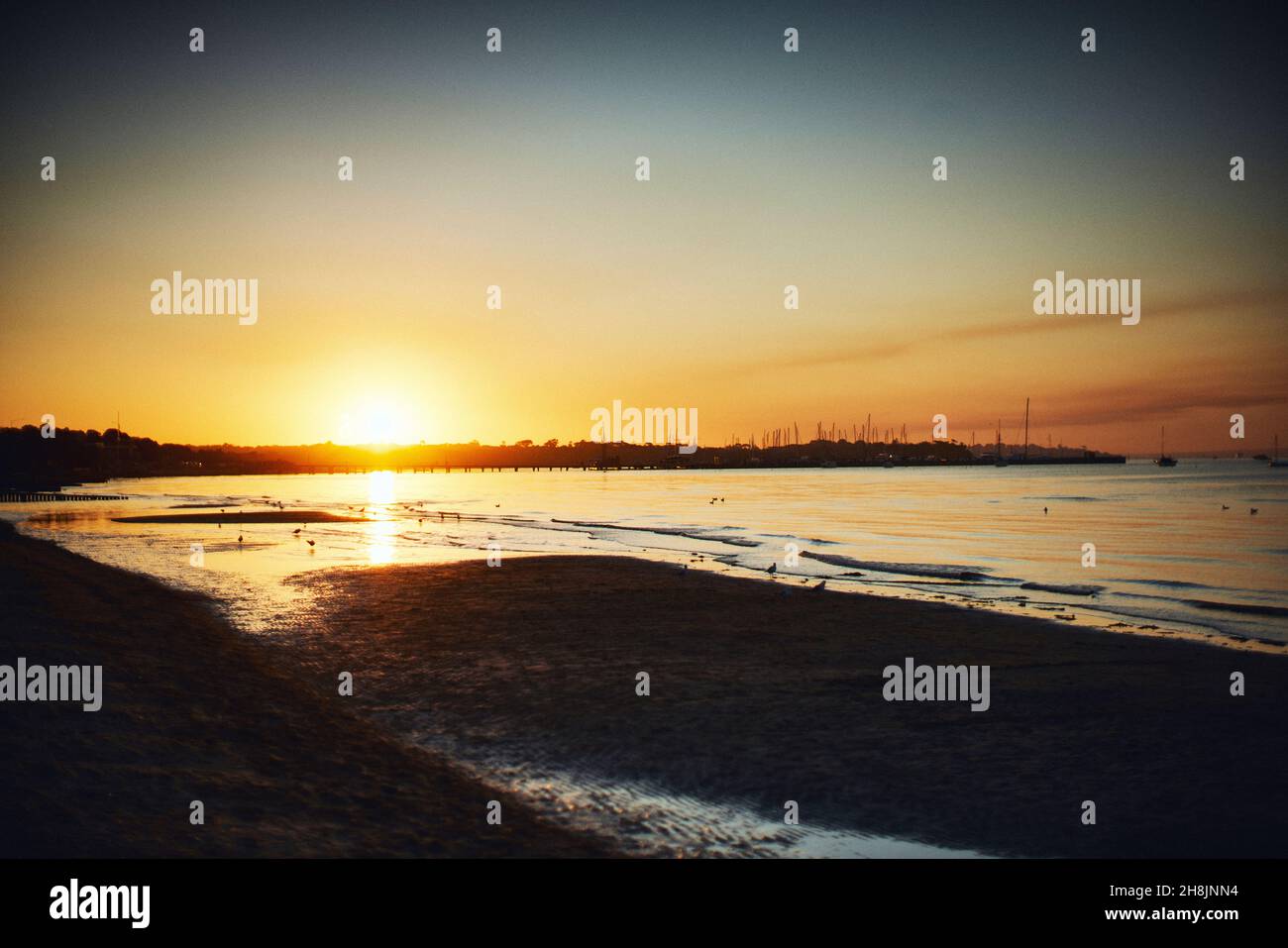 Sun setting/rising over ocean Stock Photo - Alamy