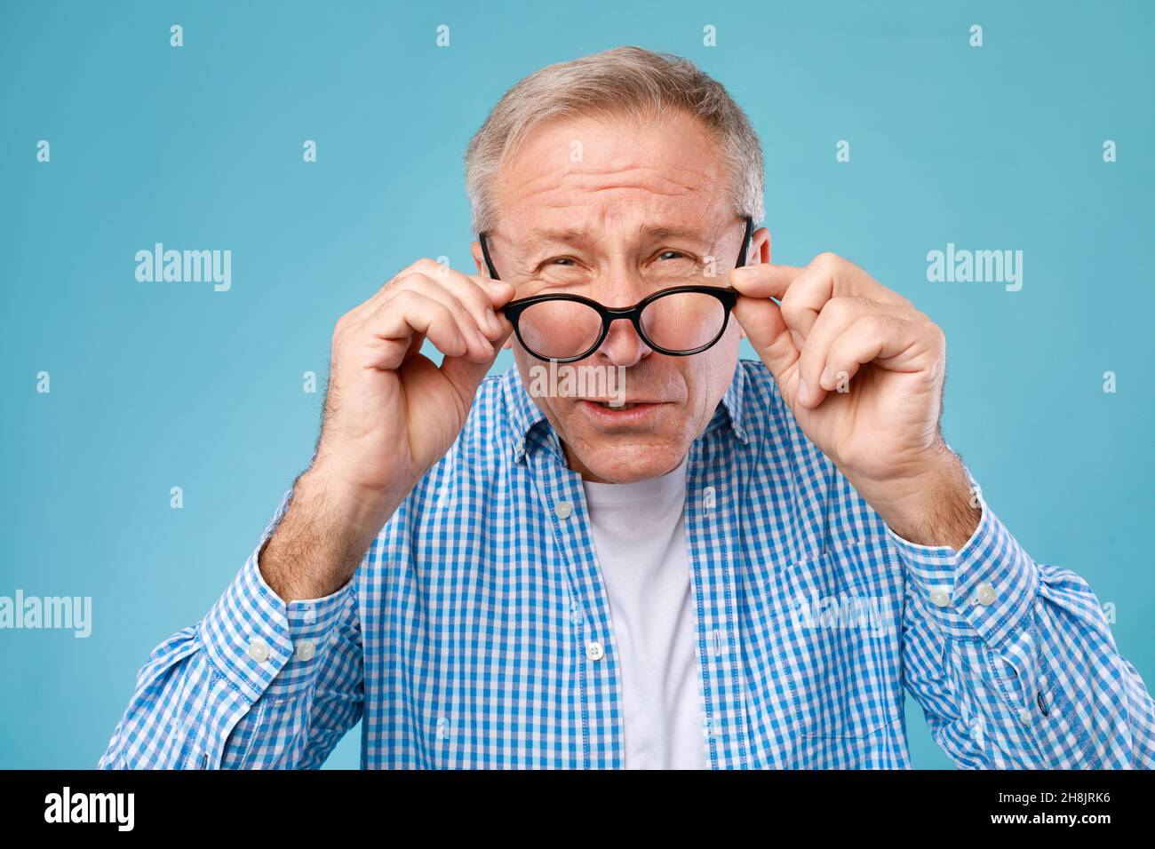 Mature man squinting wearing eyeglasses, looking at camera Stock Photo ...