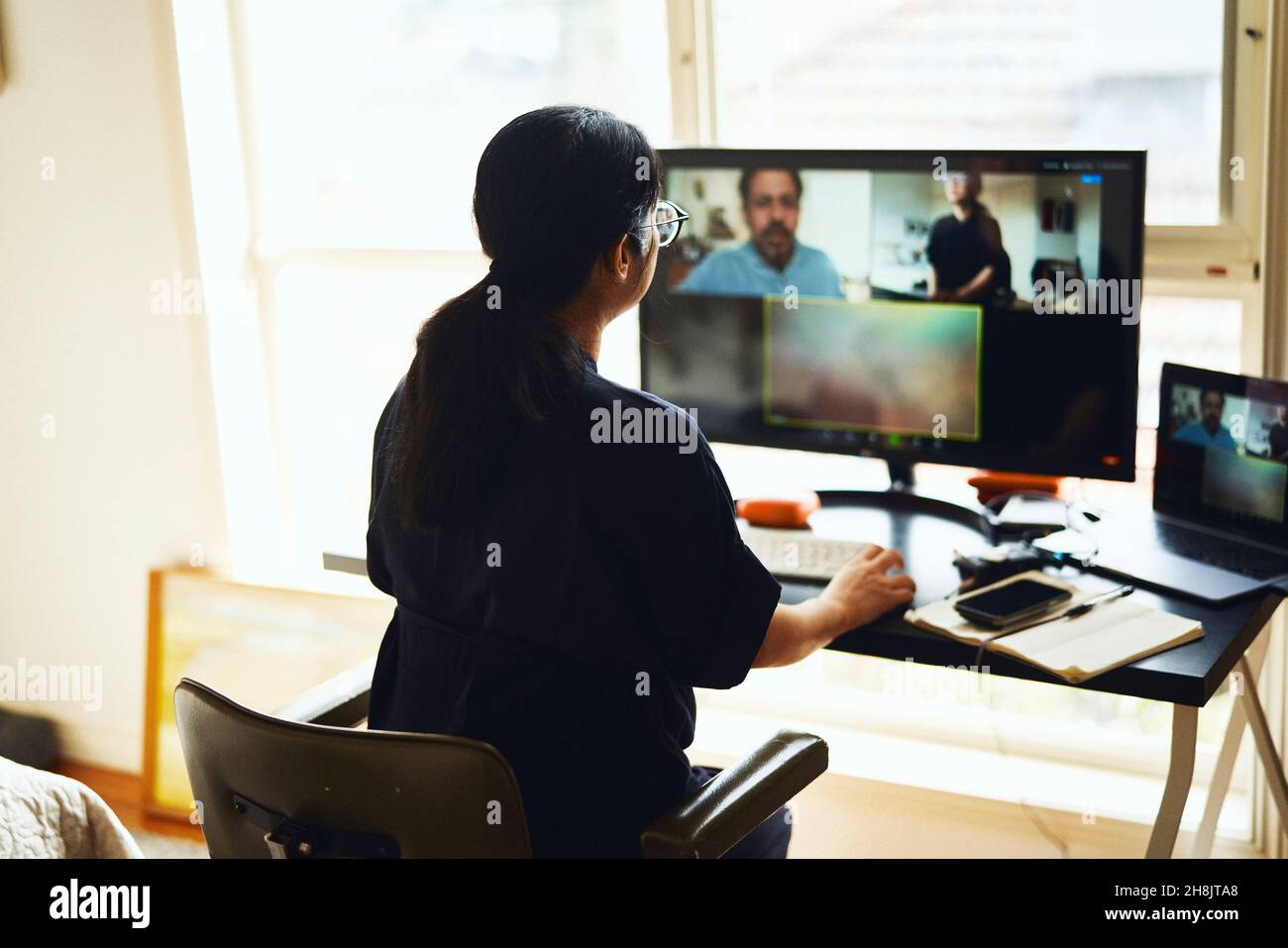 Businesswoman working from home, using multiple screens Stock Photo - Alamy