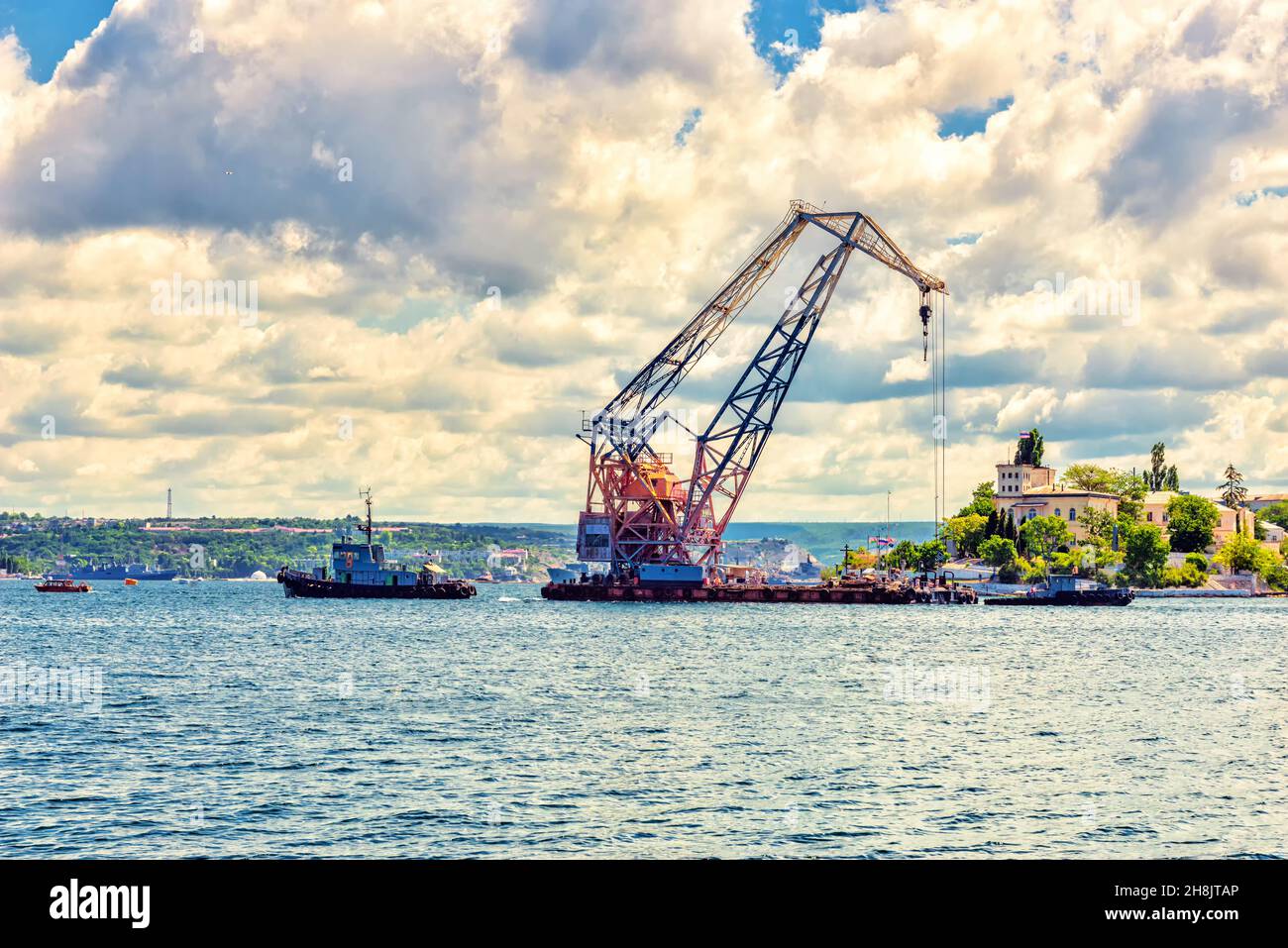 Moving a large floating port crane Stock Photo - Alamy