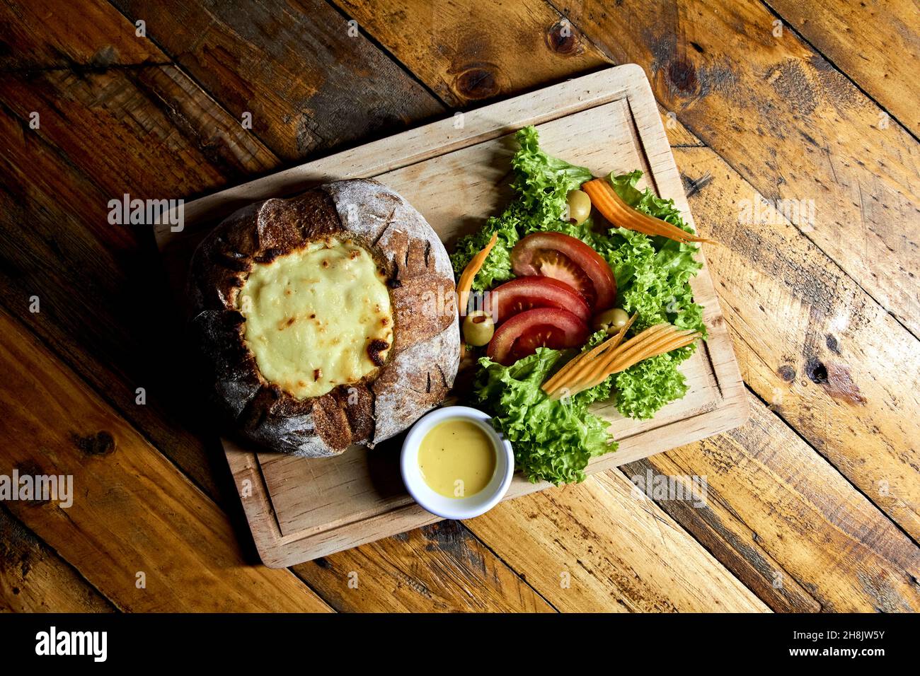 peasant bread stuffed with meat and chicken covered with cheese with ...
