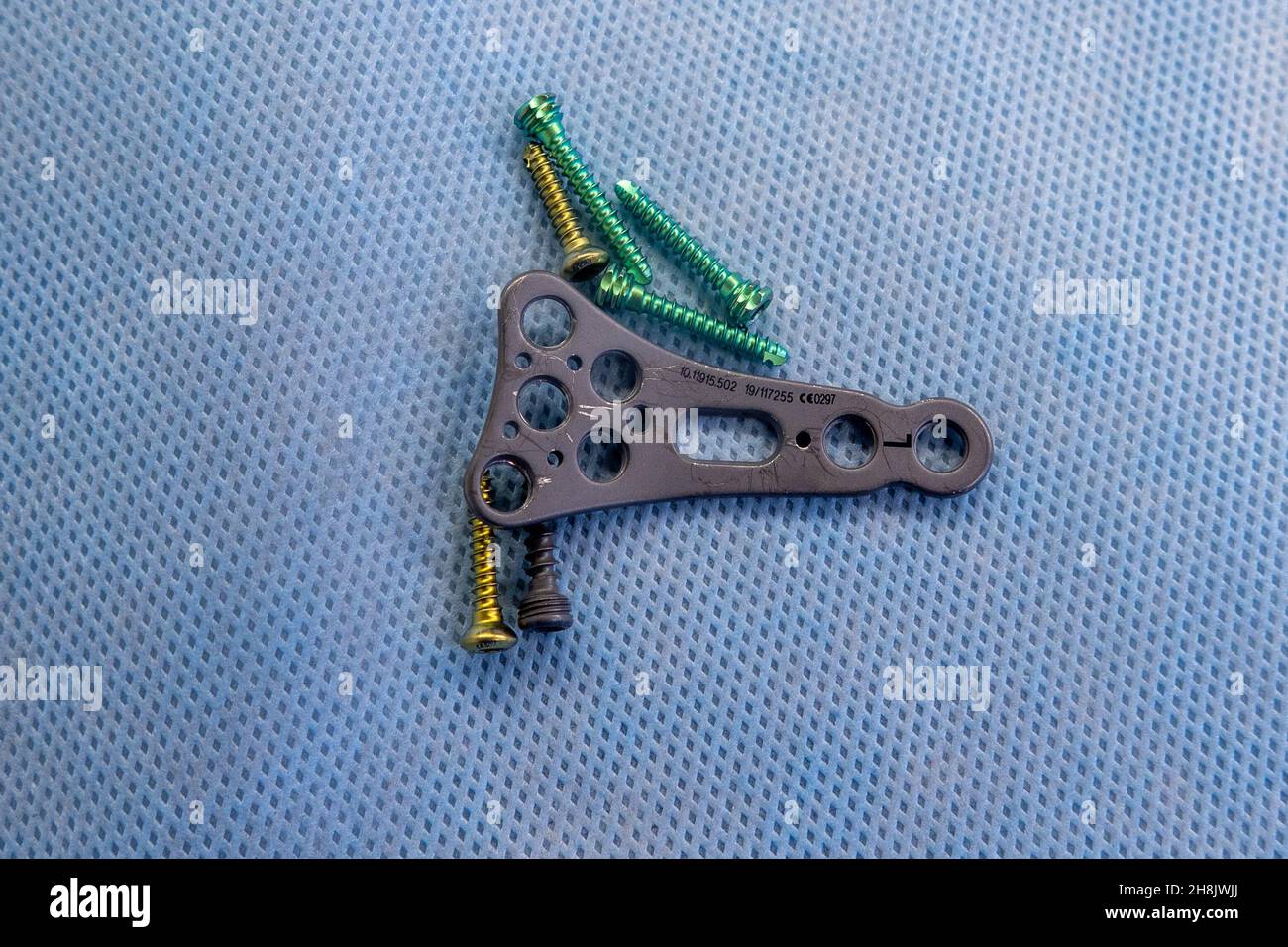 explanted titanium plate and various titanium screws of a radius ...