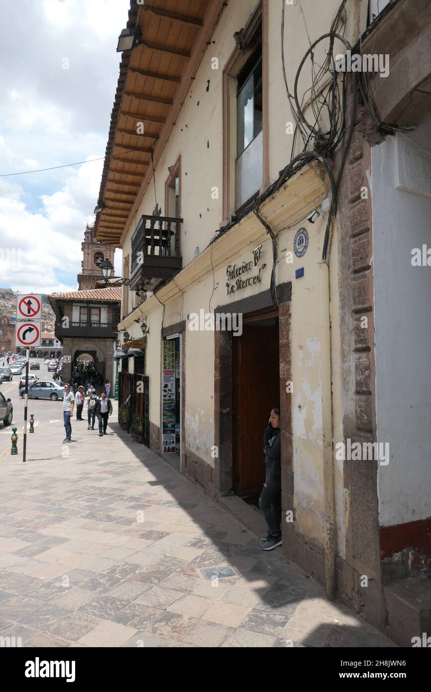 Cusco Peru shop street person local locals balcony signs sign cables ...