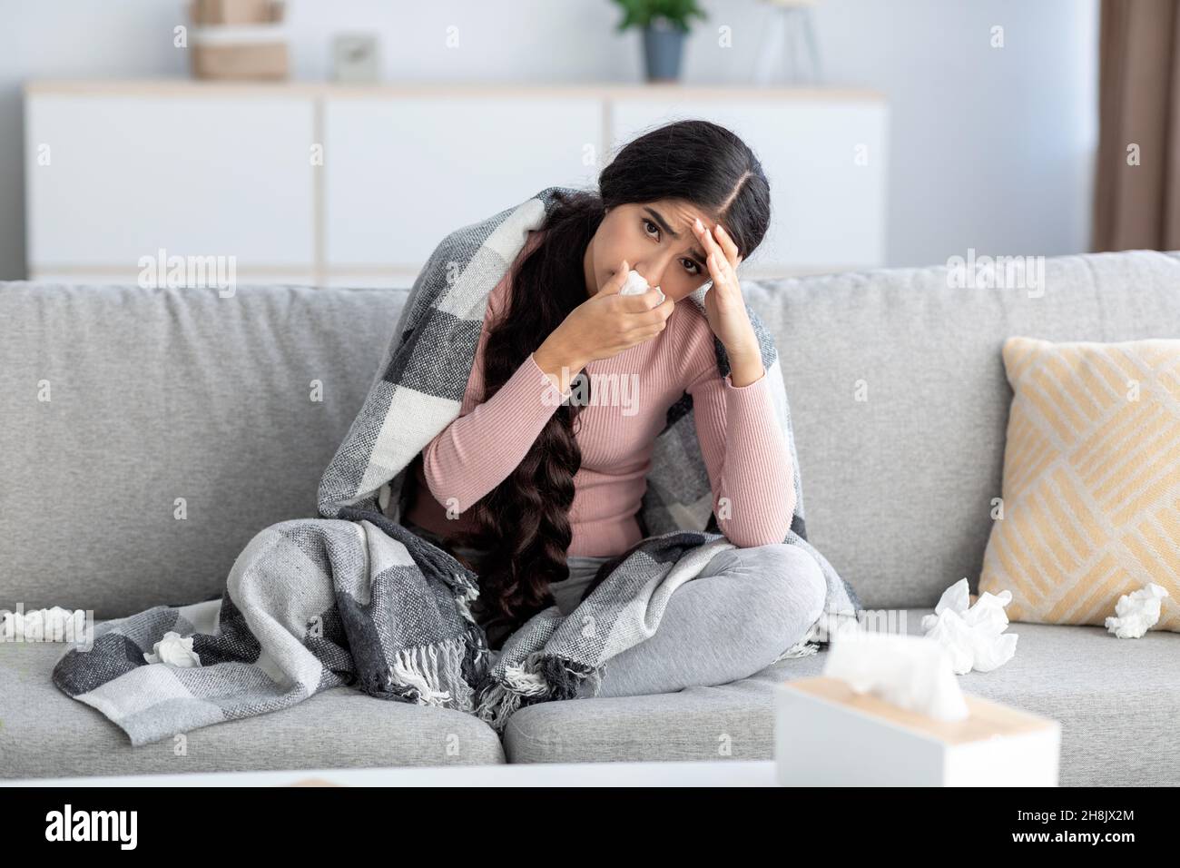 Frustration millennial indian female blows nose in napkin suffers from ...