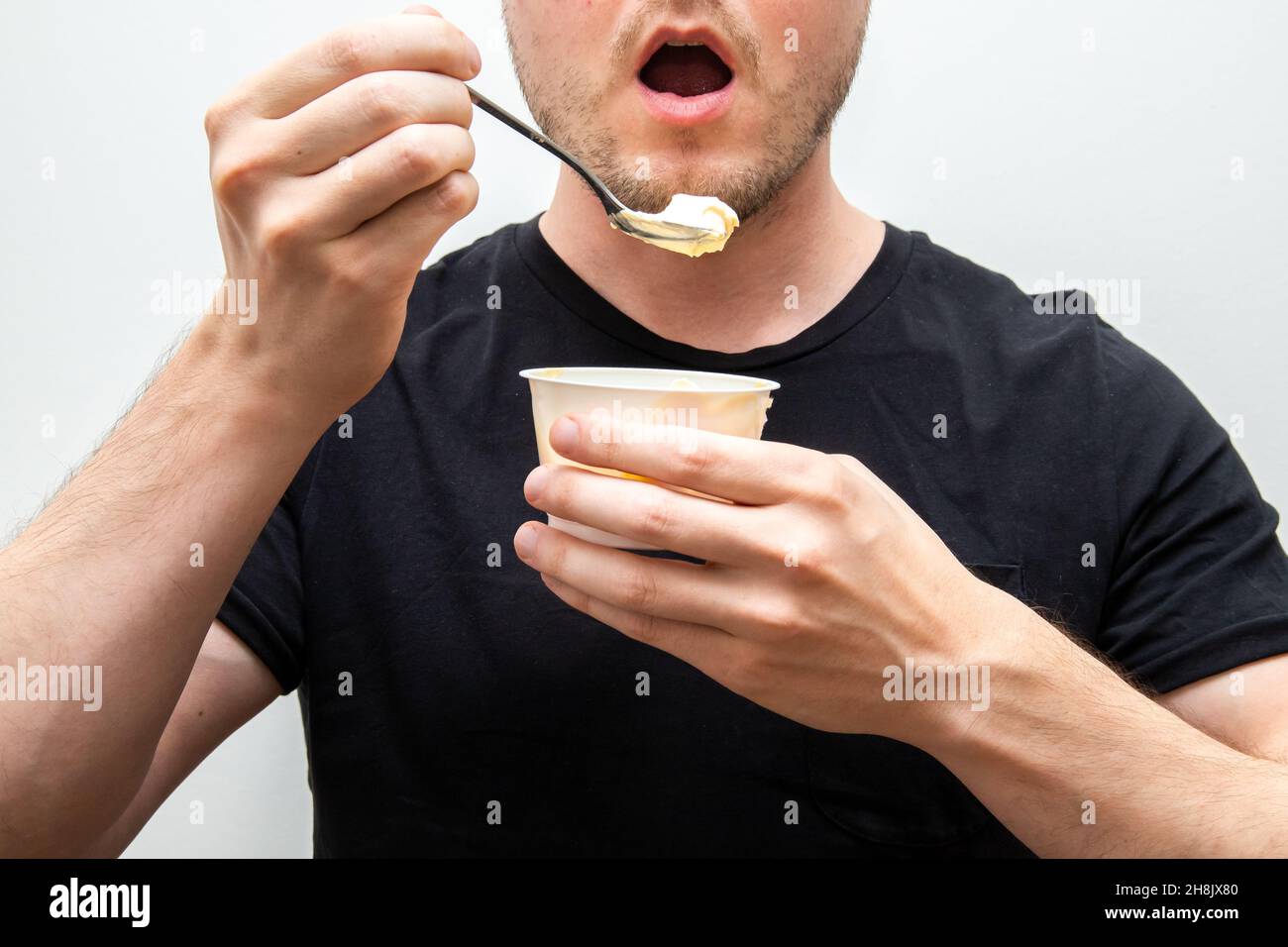 Man is eating yogurt; healthy lifestyle concept Stock Photo - Alamy