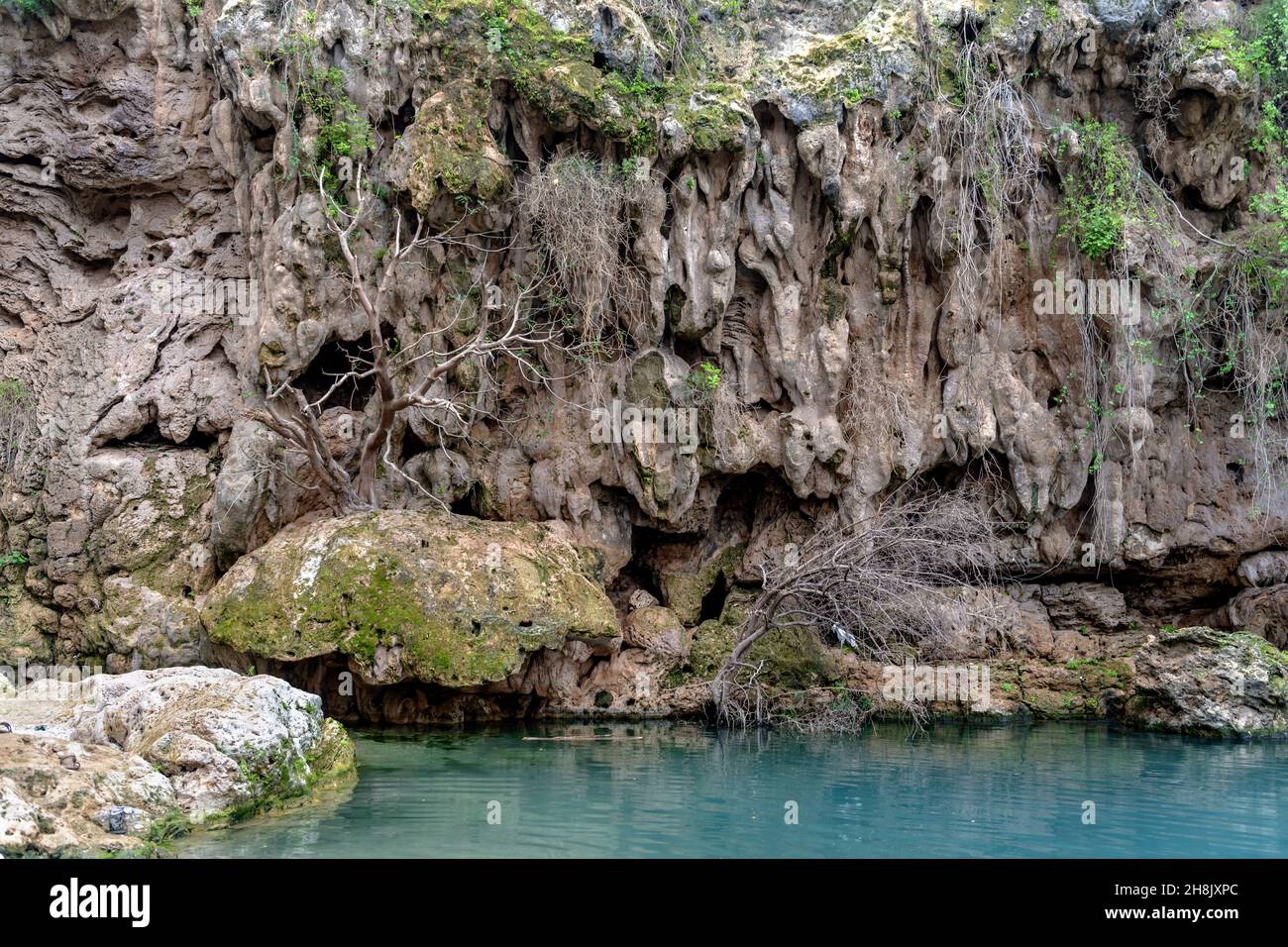 Beautiful scene of rocky cliff with holes on a blue clear water Stock ...