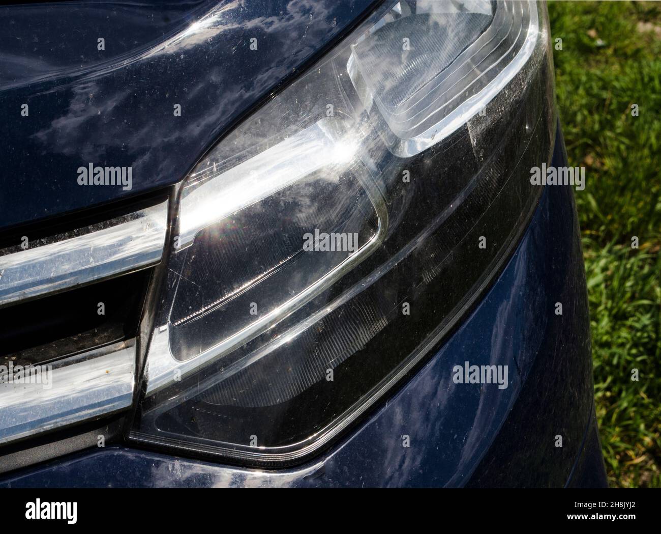 Modern car headlights with sky reflection on them. Car headlight close ...