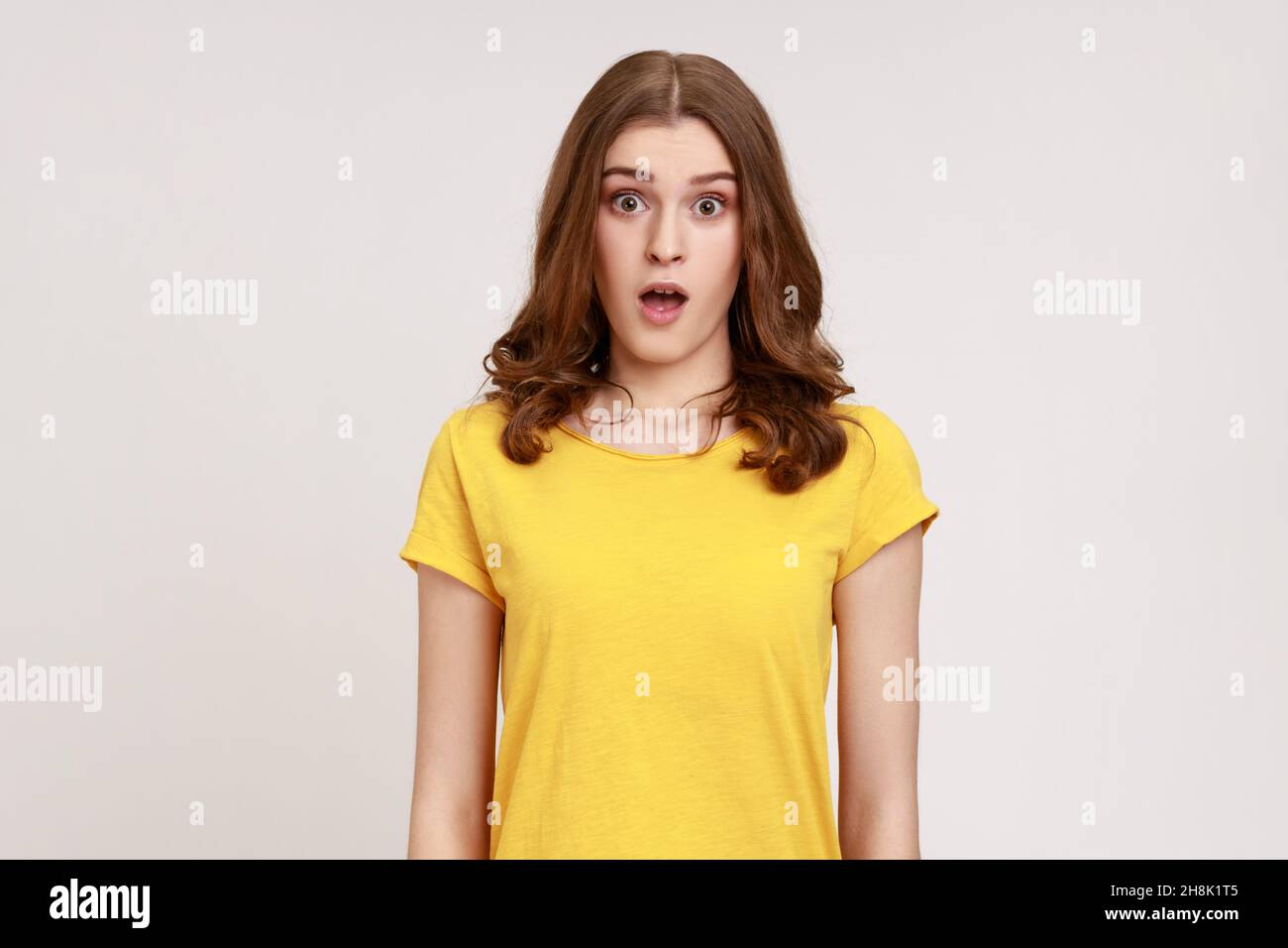 Wow, unbelievable. Portrait of attractive amazed woman with wavy hair ...