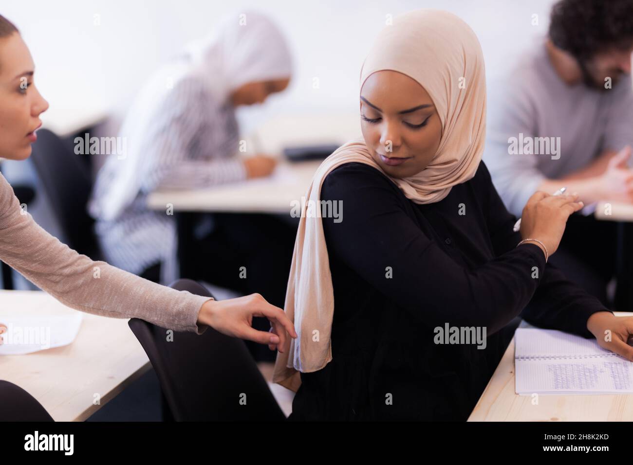 Students taking a test in a classroom. Smart young girls talking and ...
