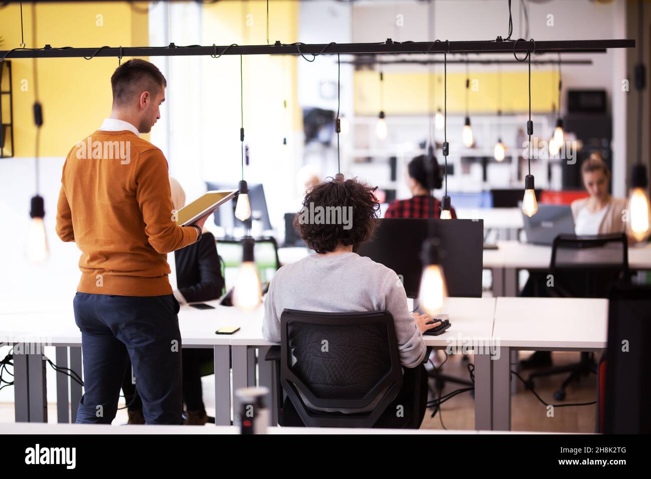 Business people having conversation in front of a computer in modern ...