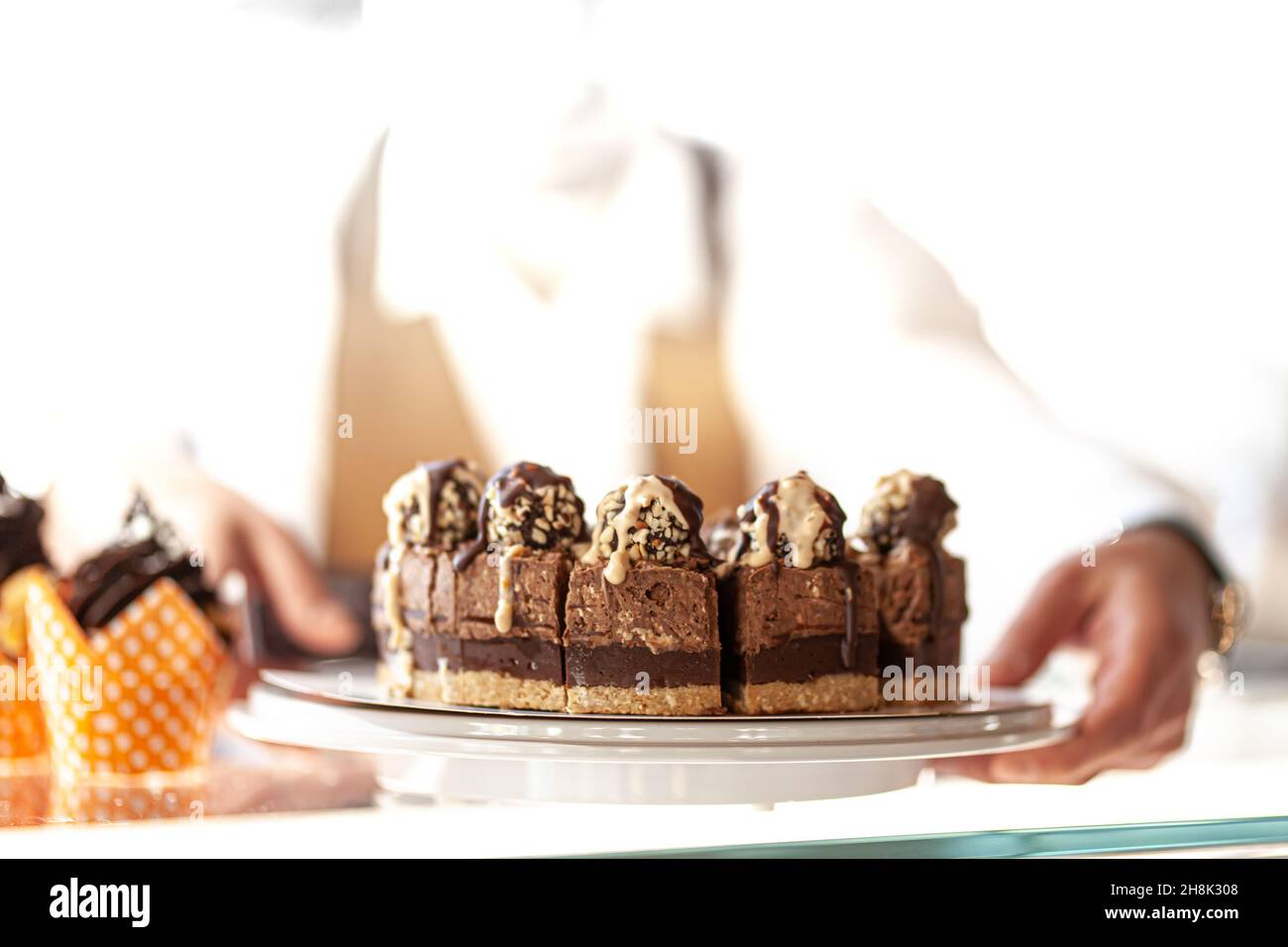 Waiter hands holding chocolate cake in a restaurant Stock Photo - Alamy