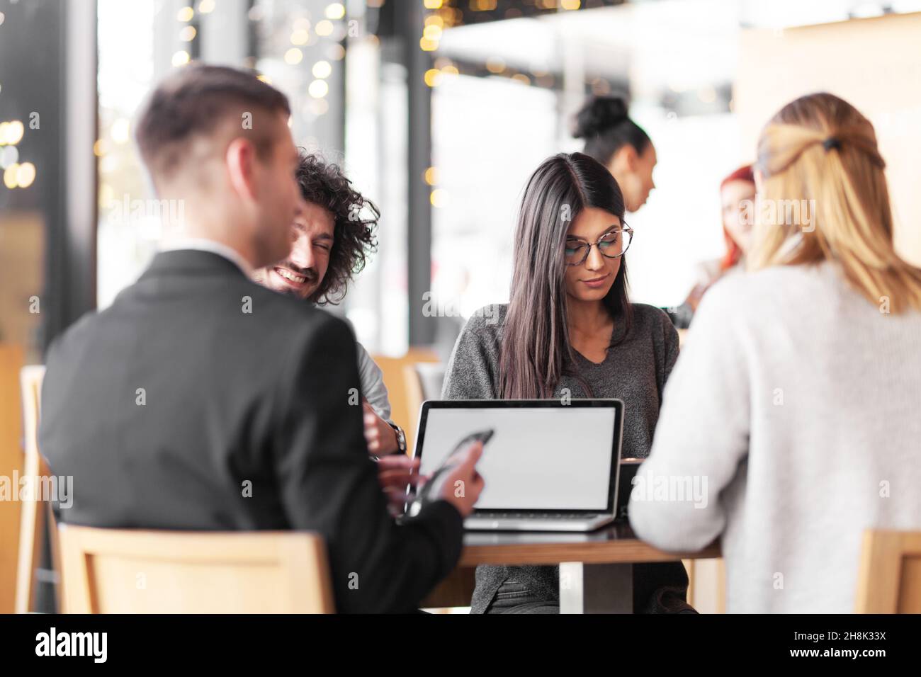 Young successful business people having a meeting at a cafe. Smiling ...