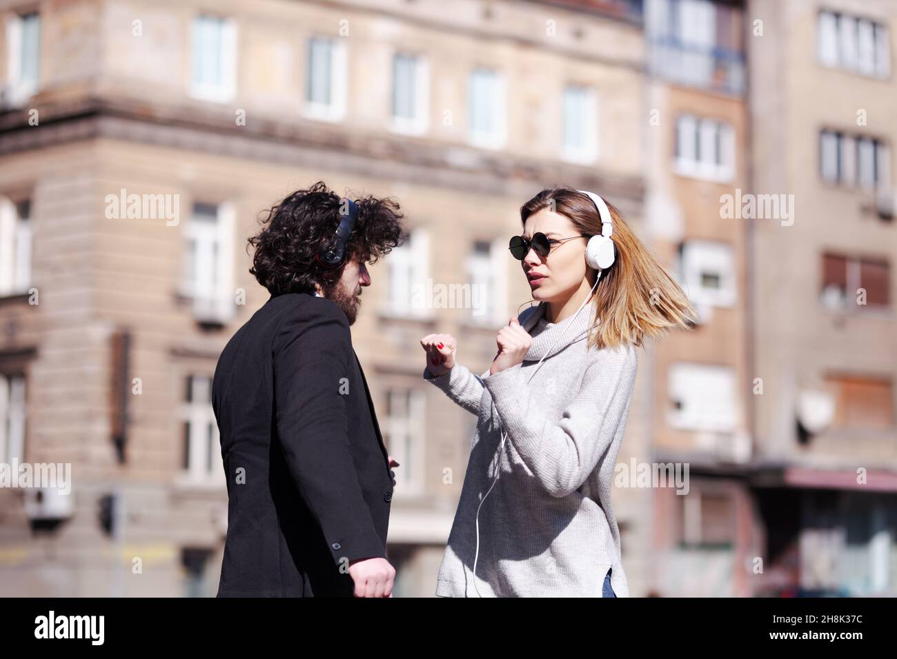 Young business colleagues dancing together with headphones after work ...