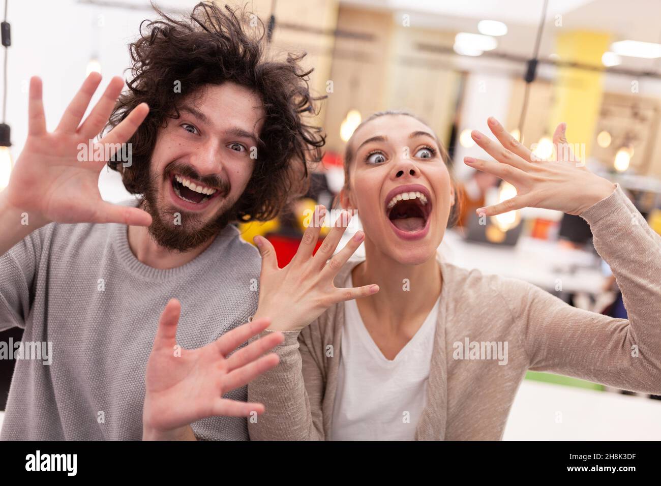 Friendly colleagues fooling around in a modern coworking office space ...