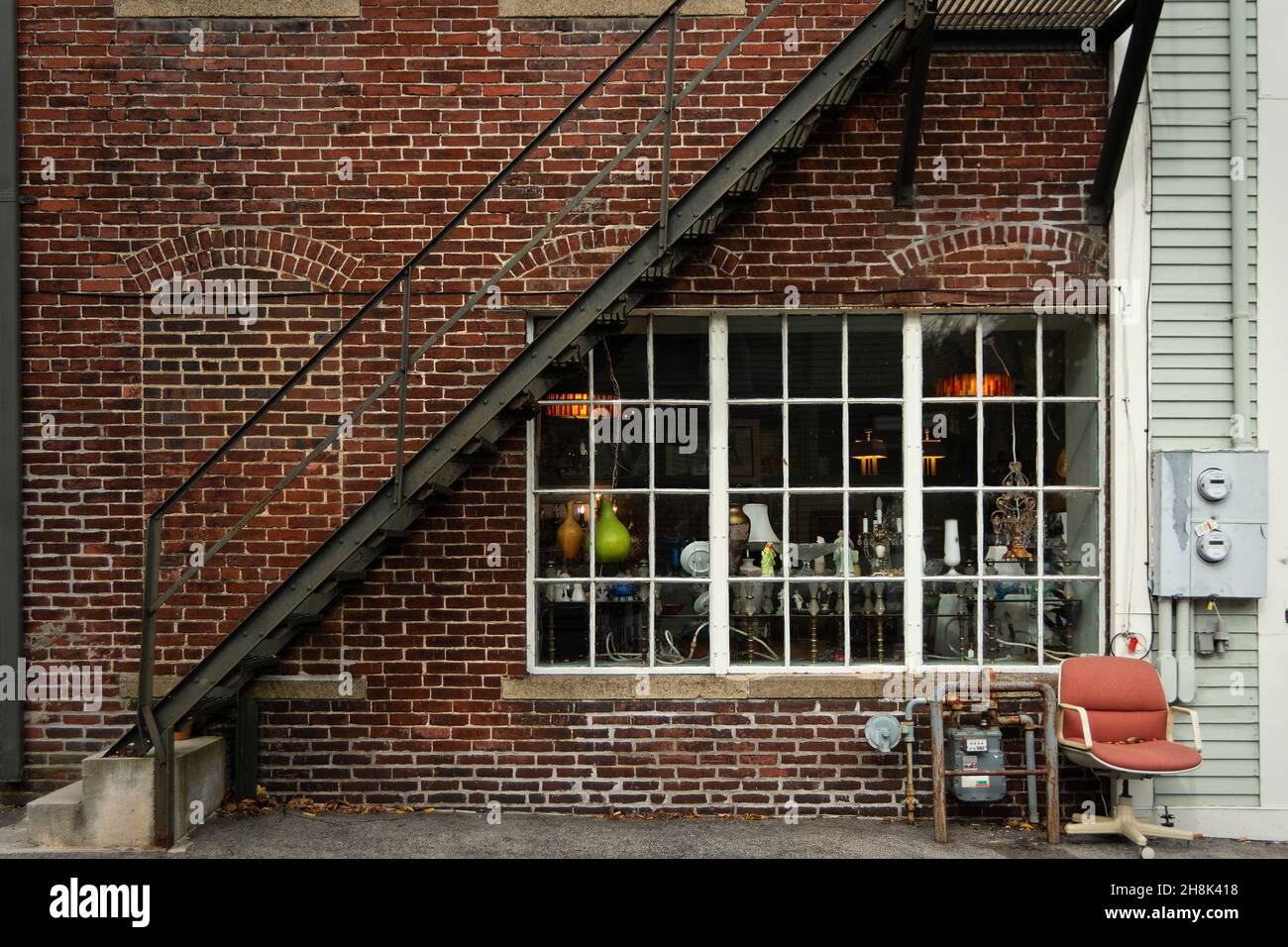 Brick storefront with a large window displaying lights with a discarded ...