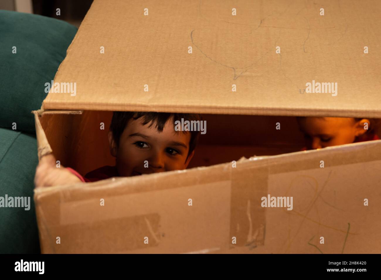 Child playing and looking through the crack of a cardboard box Stock ...