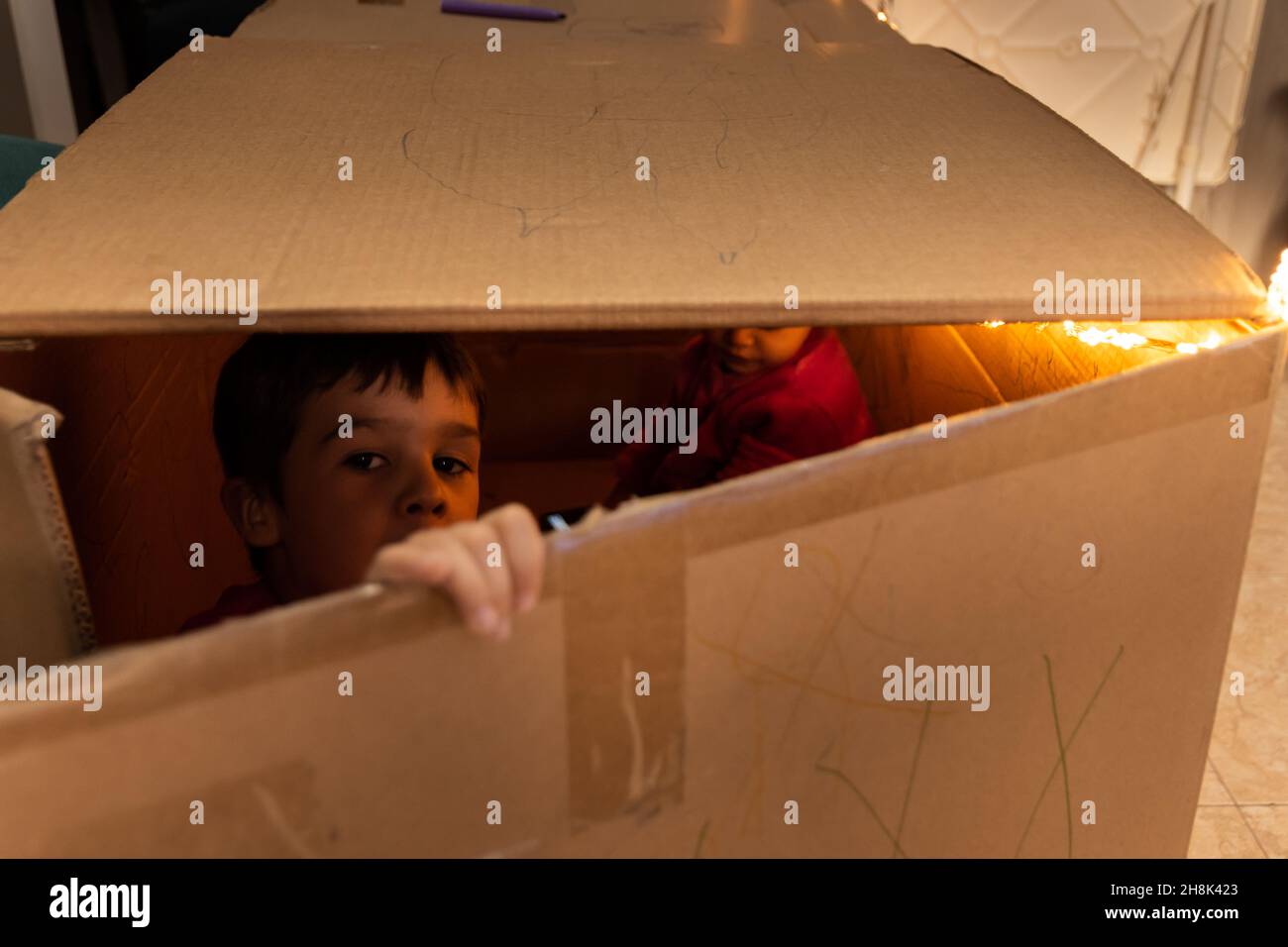 Child playing and looking through the crack of a cardboard box Stock ...