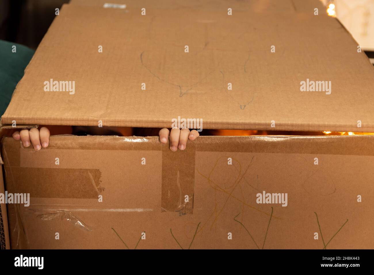 Child playing and looking through the crack of a cardboard box Stock ...