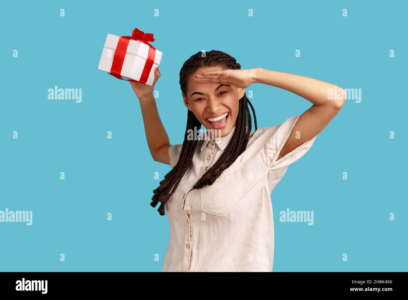 Portrait of excited satisfied woman with black dreadlocks holding ...
