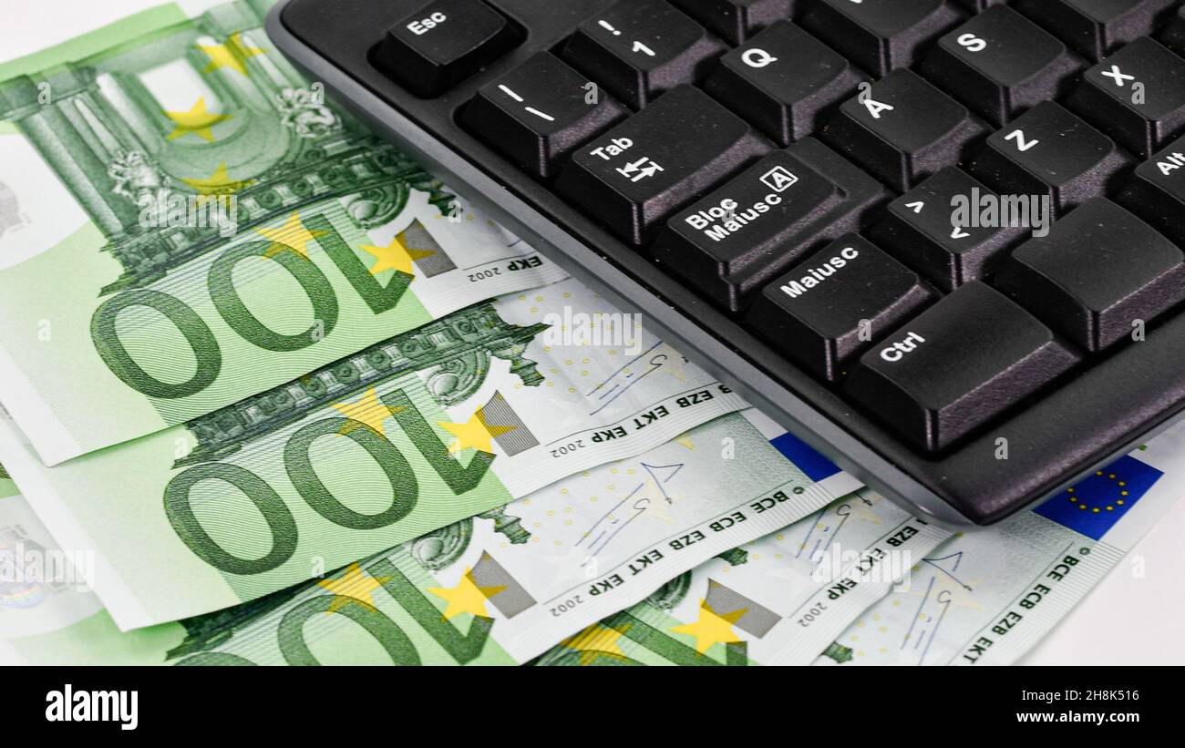 Detail of a computer keyboard and 100 euro bills in the bank Stock ...