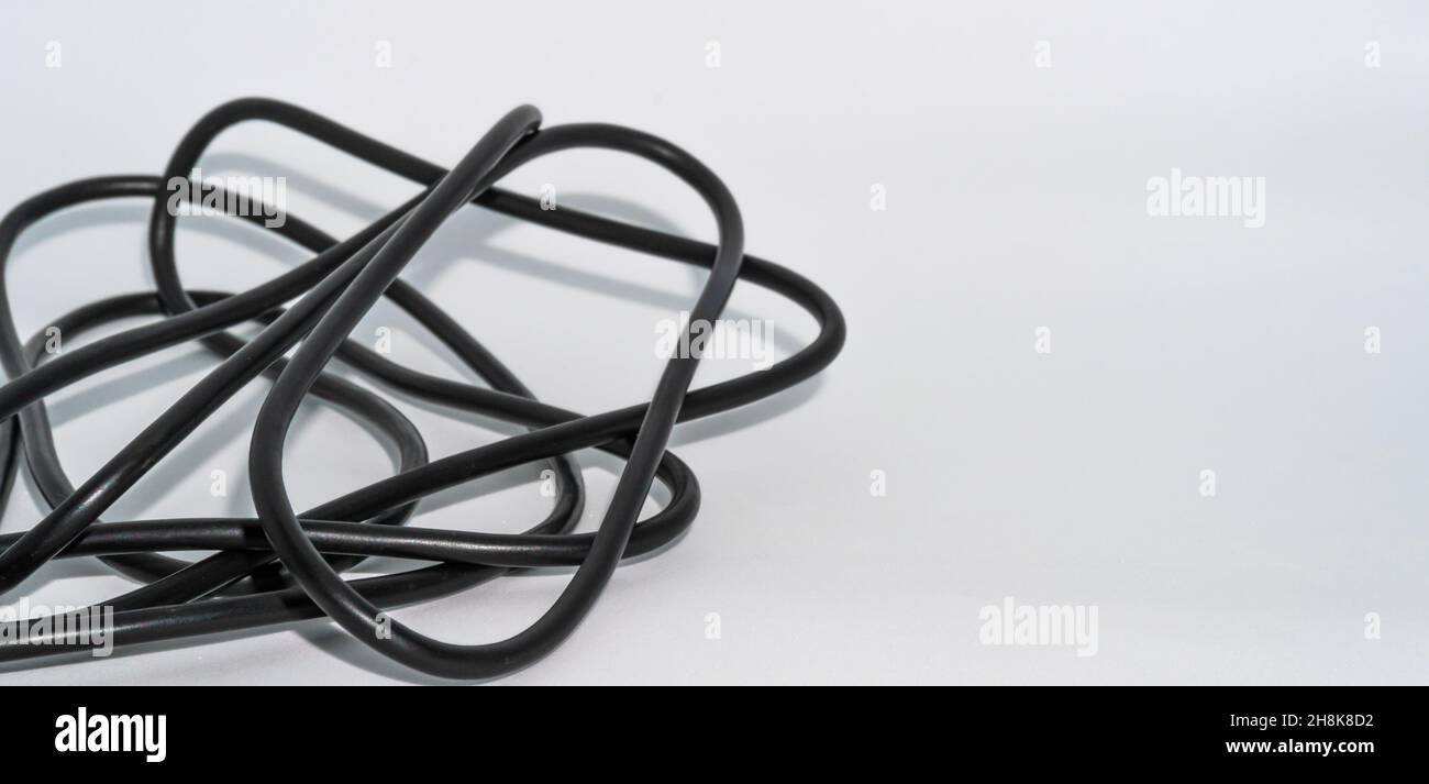 Closeup shot of black tangled wires isolated in a white background ...