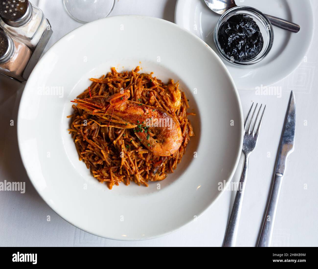 Traditional Catalan fideua with shrimps served with black aioli Stock ...