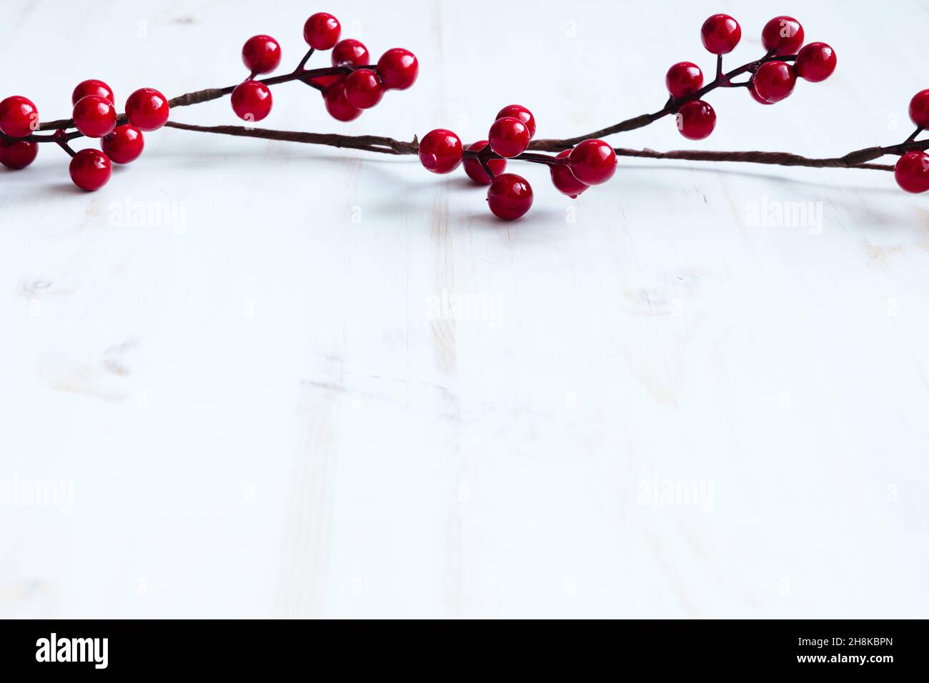 Border of red berries on a white wood background with copy space Stock ...