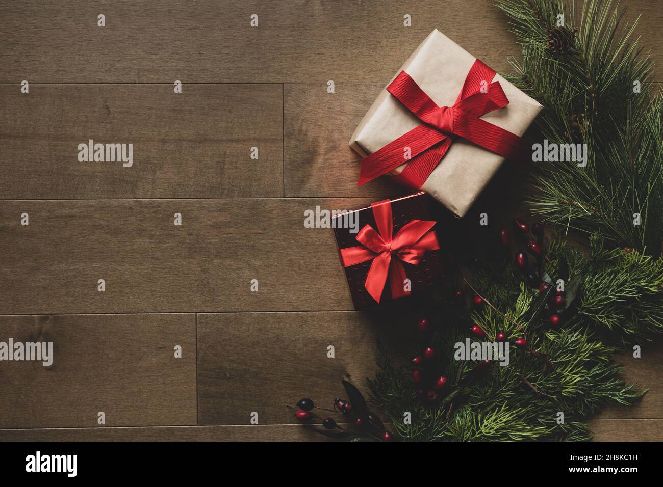 Christmas present with red ribbon and rustic wrapping paper on a wood ...