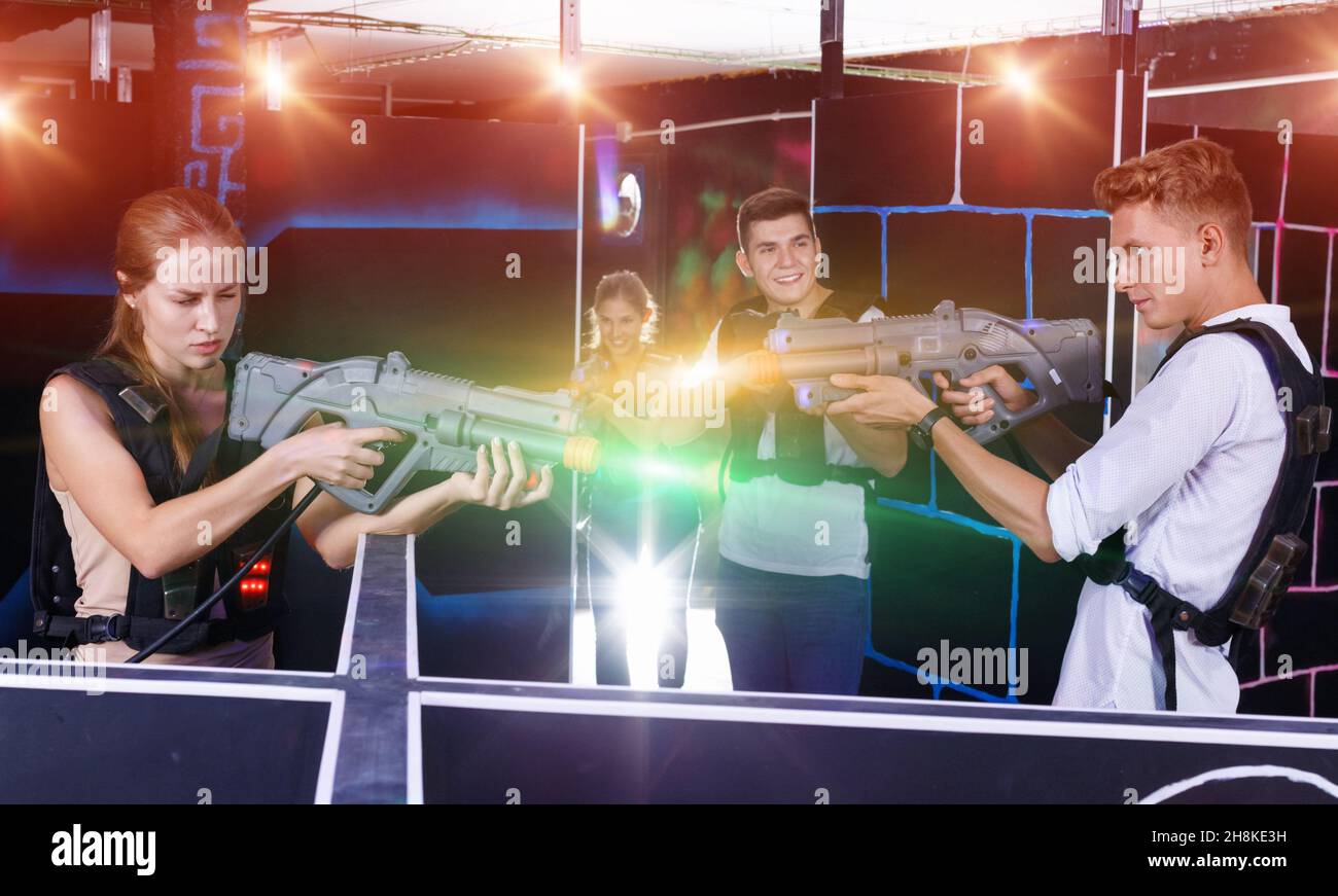 Laser tag players guys and girls playing in teams in dark laser Stock ...