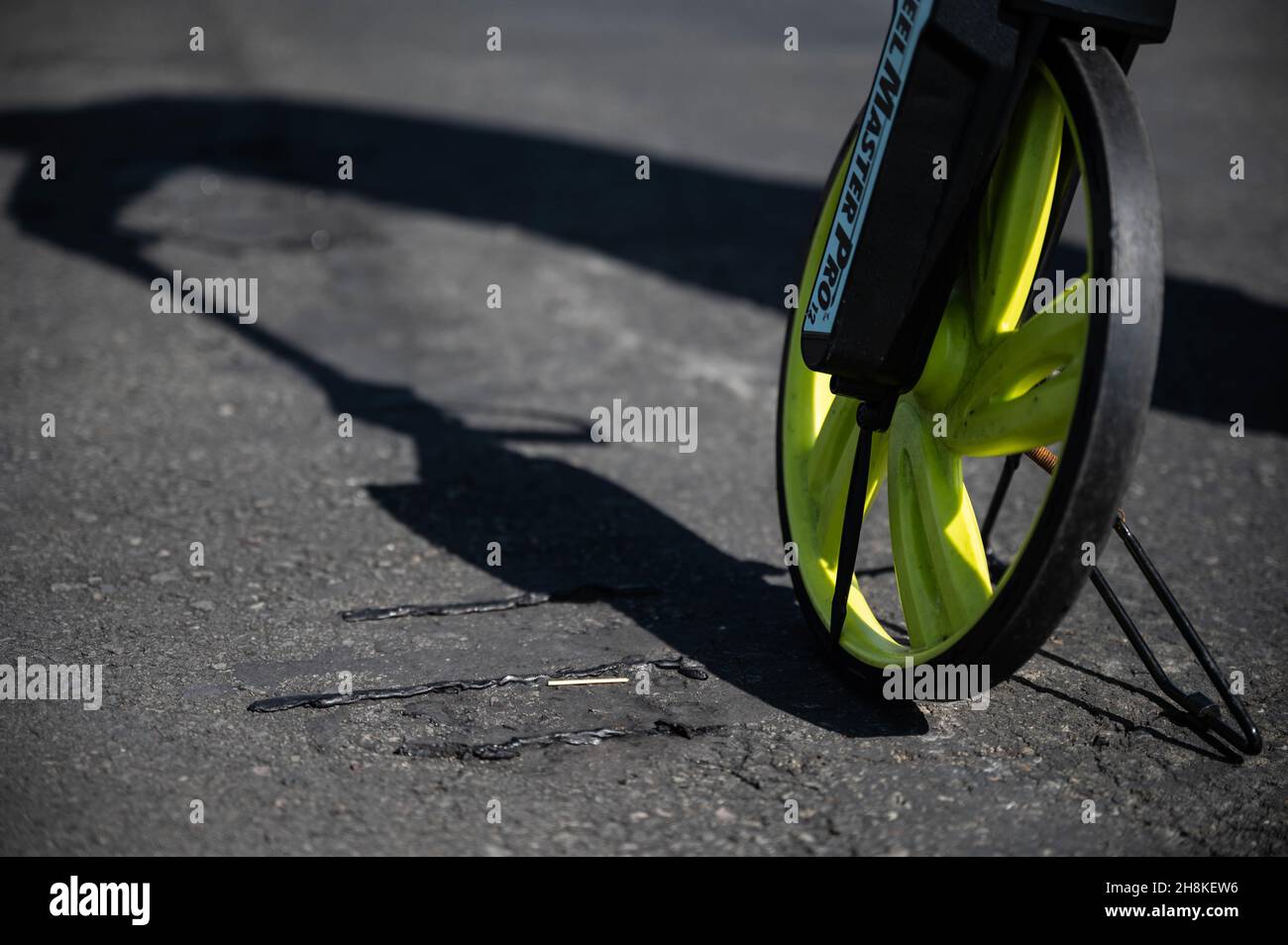 A measuring wheel is placed next to damage on the flightline created by ...