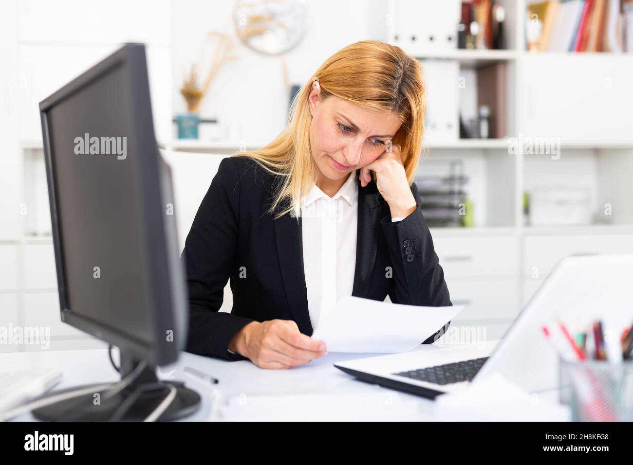 Frustrated woman working alone in office Stock Photo - Alamy