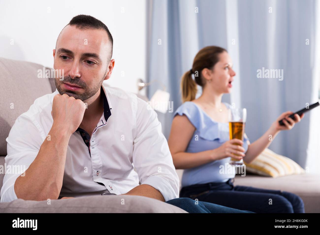 Husband is upset because his wife is watching football Stock Photo - Alamy