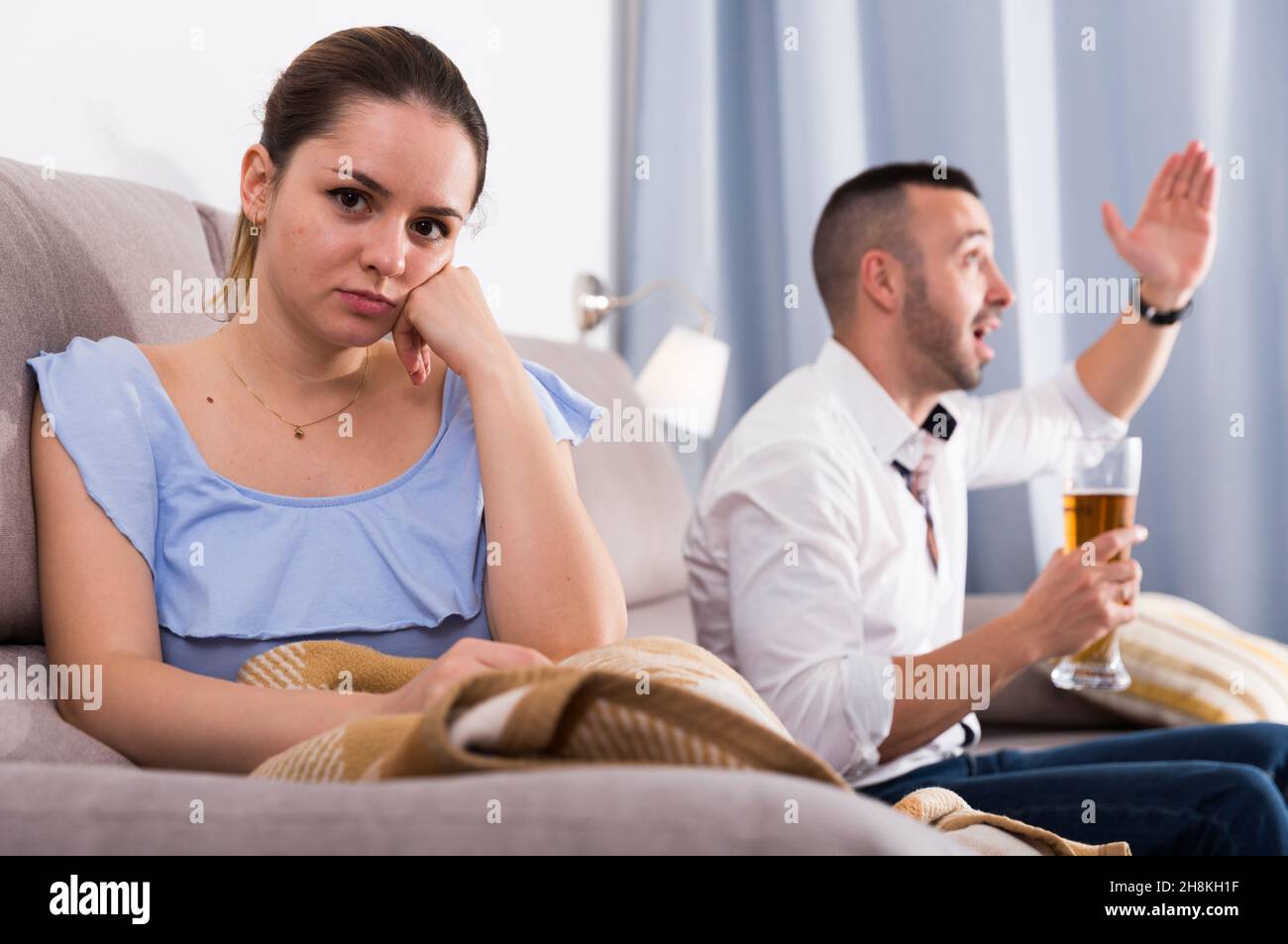 Wife is upset because her husband is watching football Stock Photo - Alamy