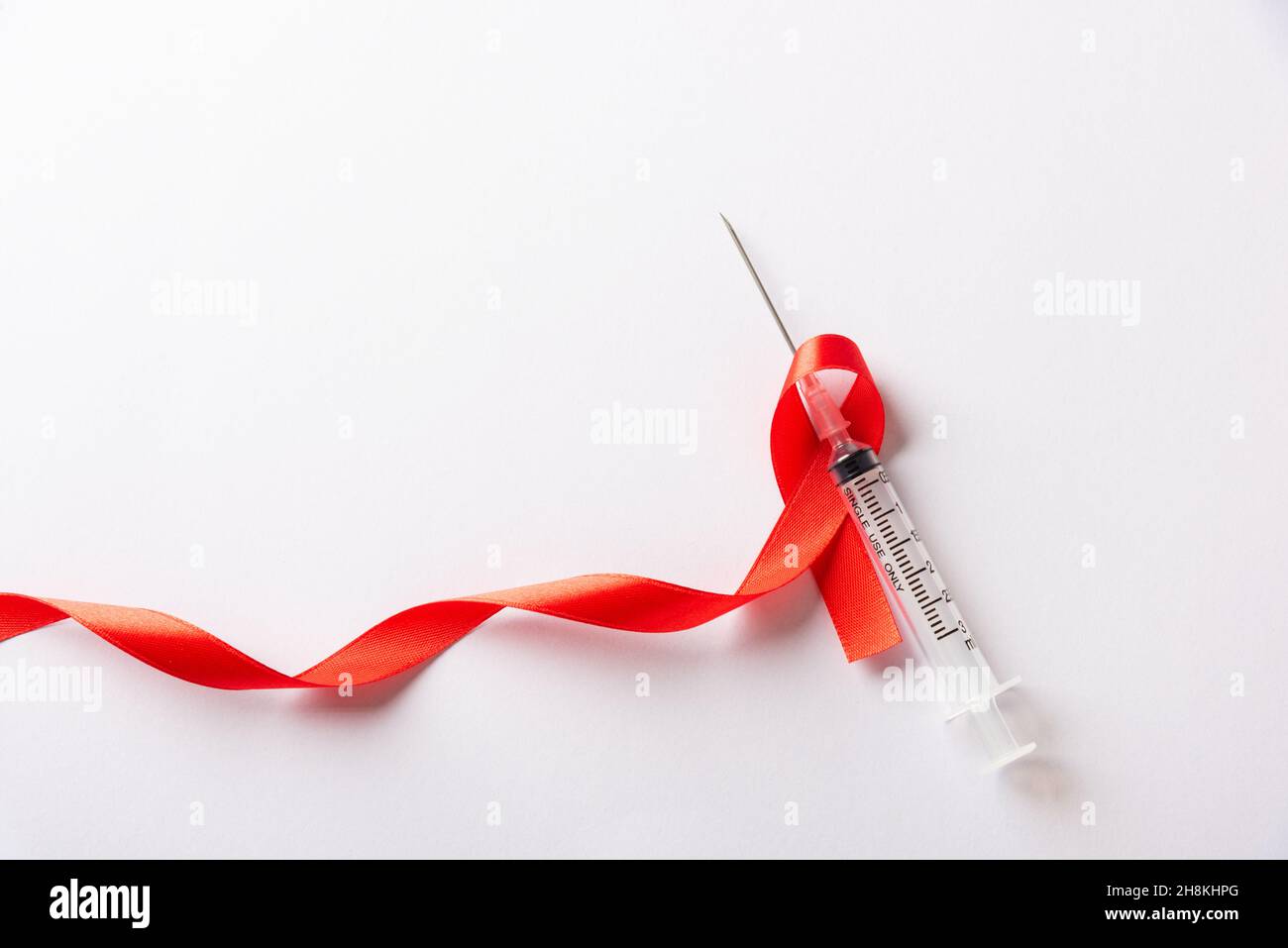 Red bow ribbon symbol HIV, AIDS cancer awareness and syringe with ...
