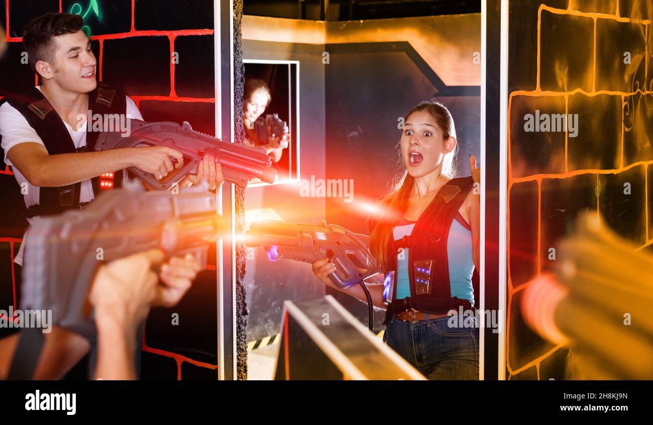 Laser tag players guys and girls playing in teams in dark laser Stock ...